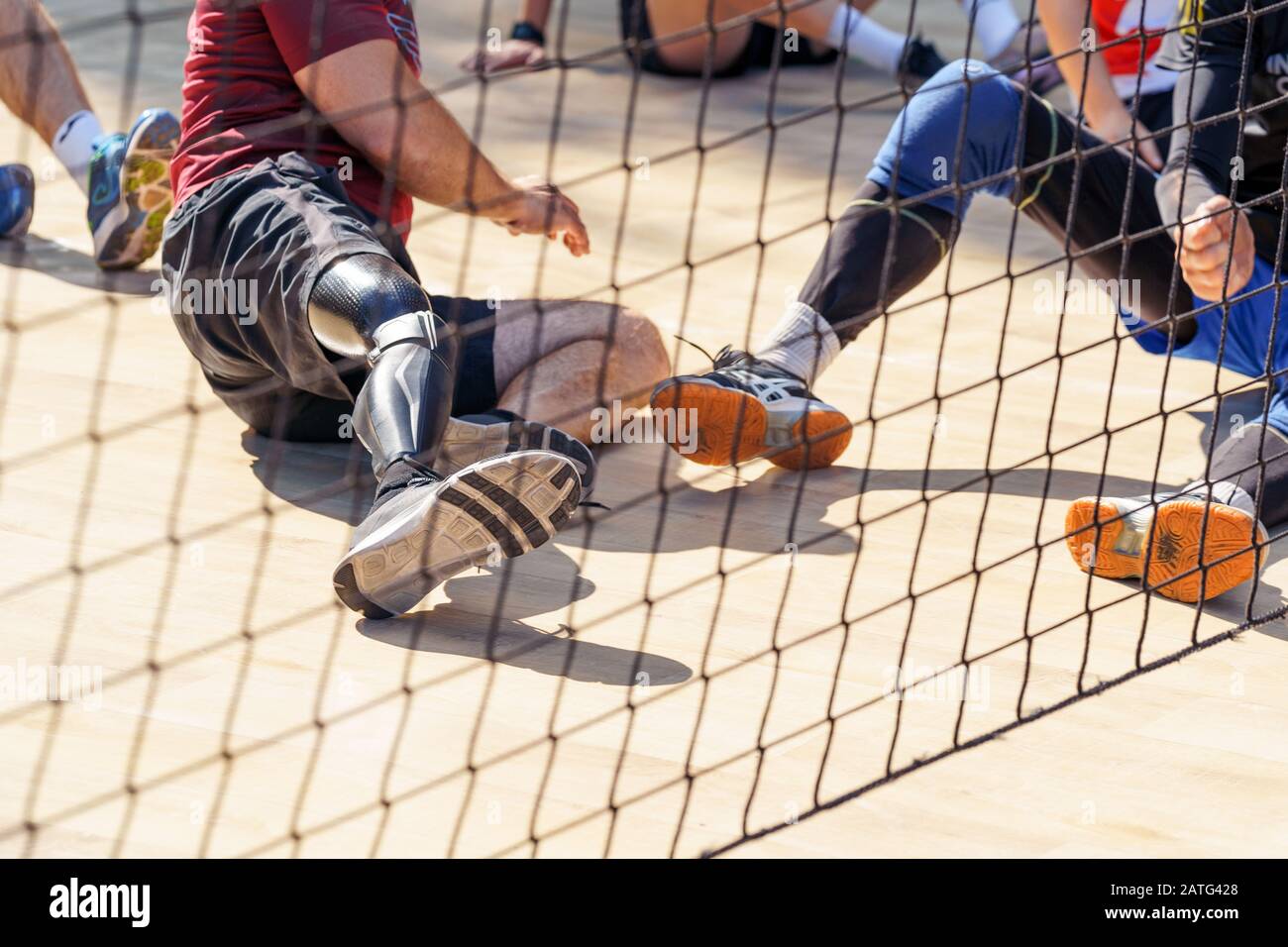 Amputee athletes playing sitting volleyball. Players with prosthetic ...