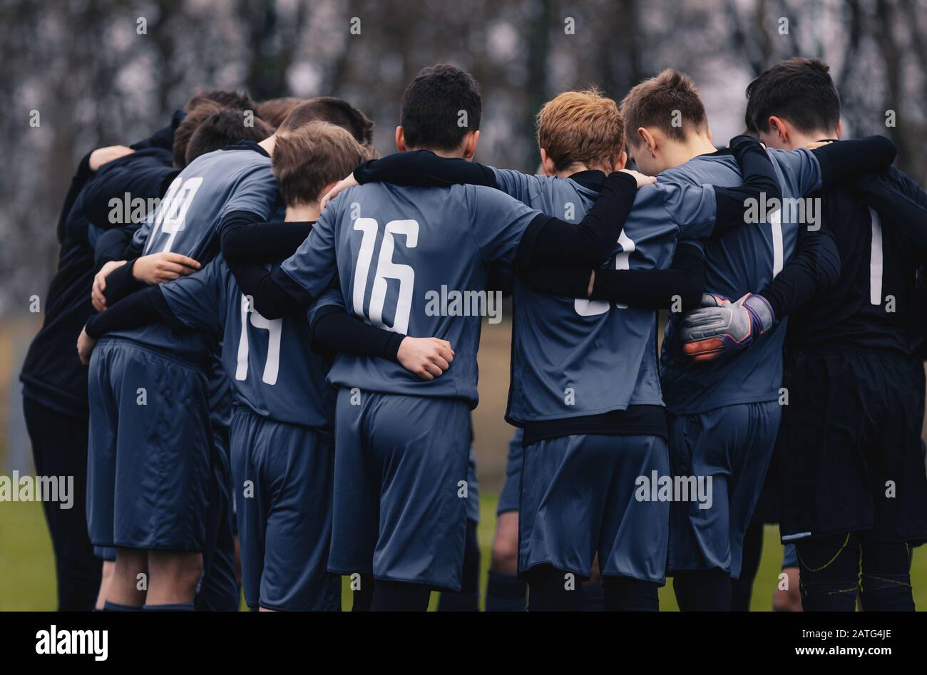 Soccer team with junior coach gathering together in a circle, to ...