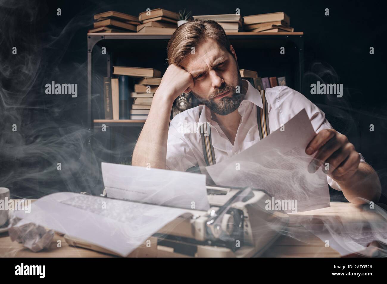 Serious bearded writer at shaded study reading his text with critical ...