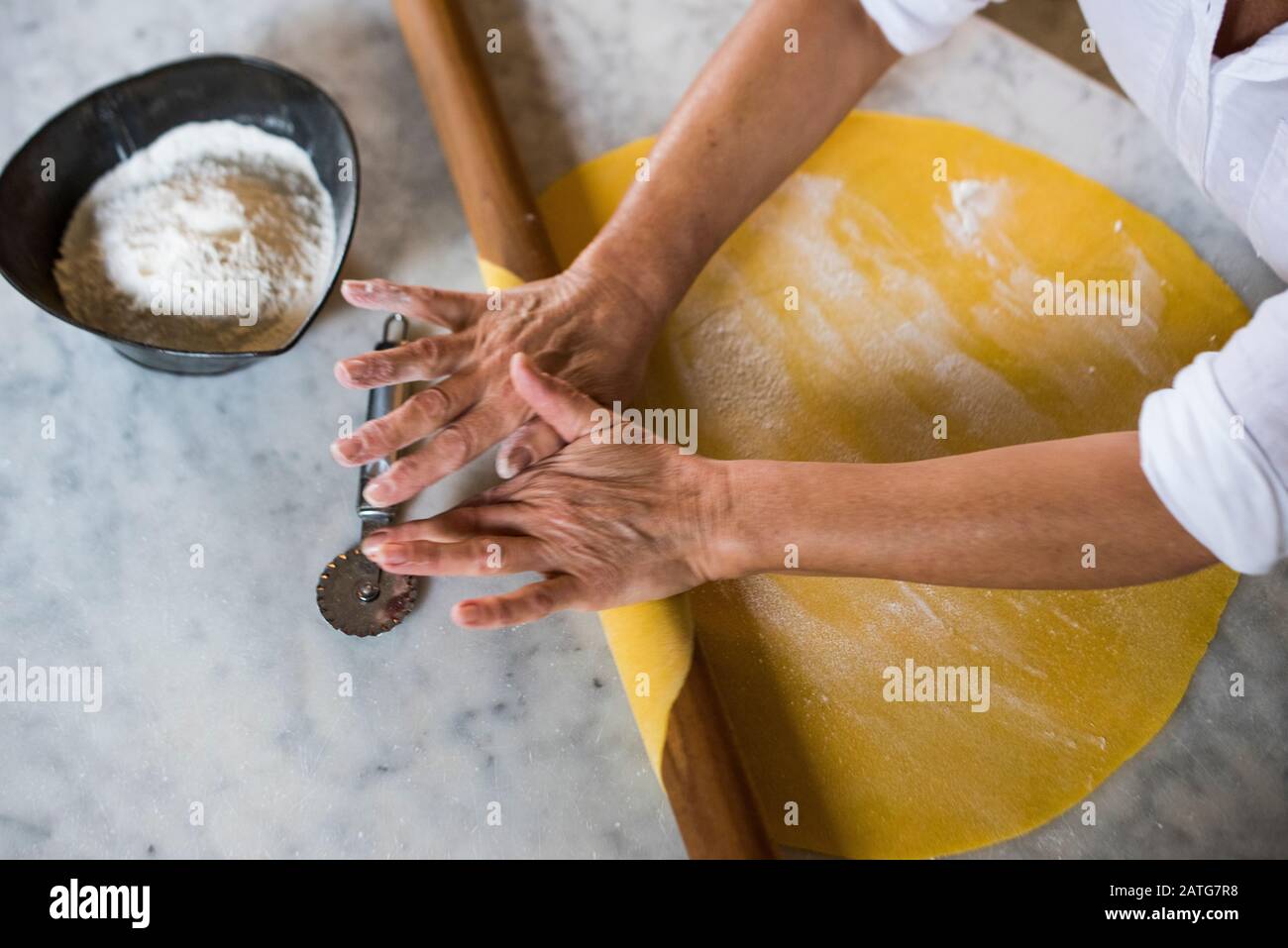 Italian woman hand rolling homemade Tortellini pasta dough Stock Photo ...