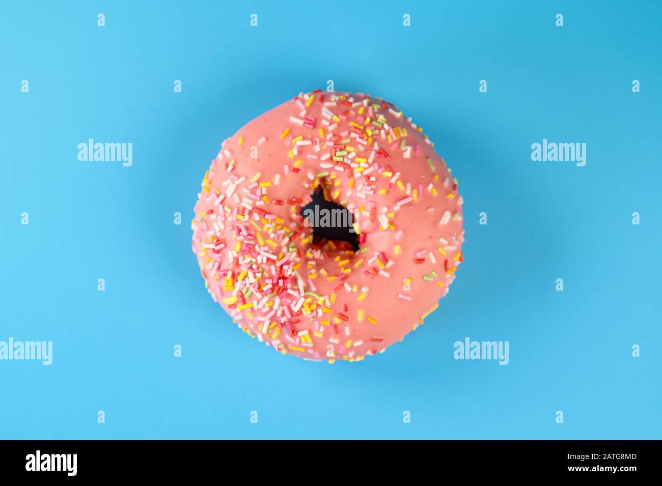 Pink iced donut on blue background. Sweet dessert top view Stock Photo ...