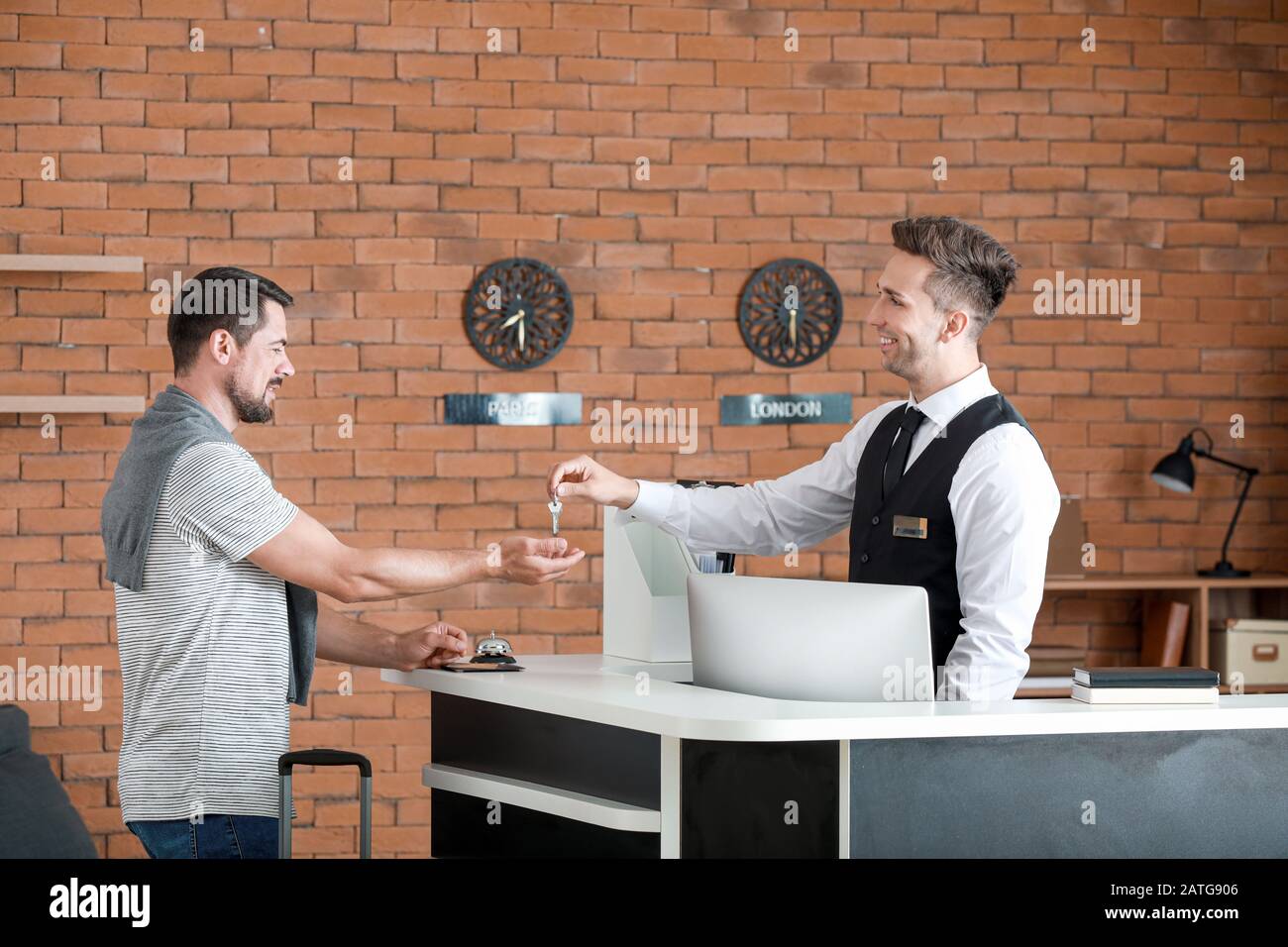Man receiving keys from hotel room at reception Stock Photo - Alamy