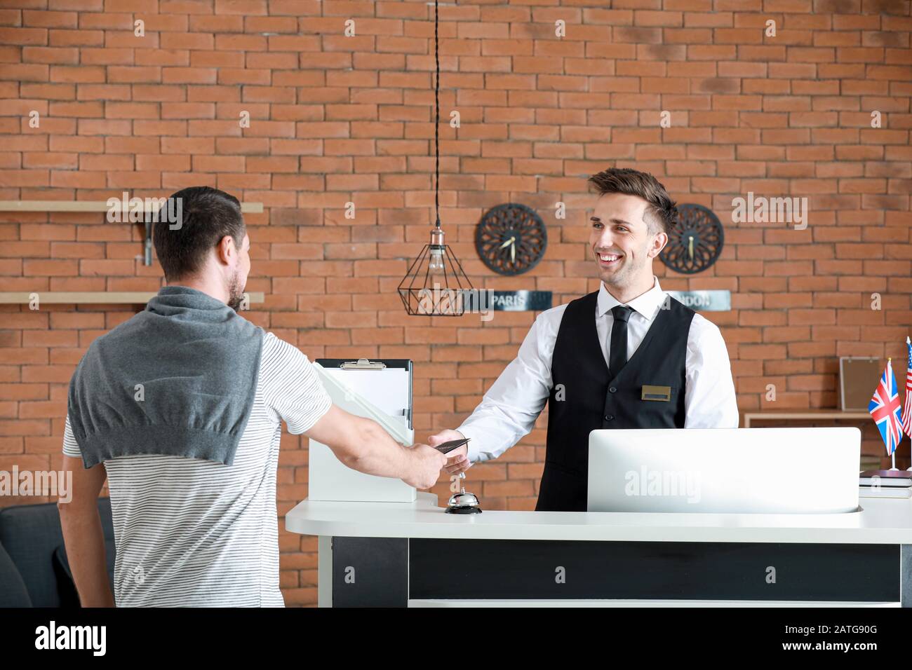 Man booking room in hotel at reception Stock Photo - Alamy