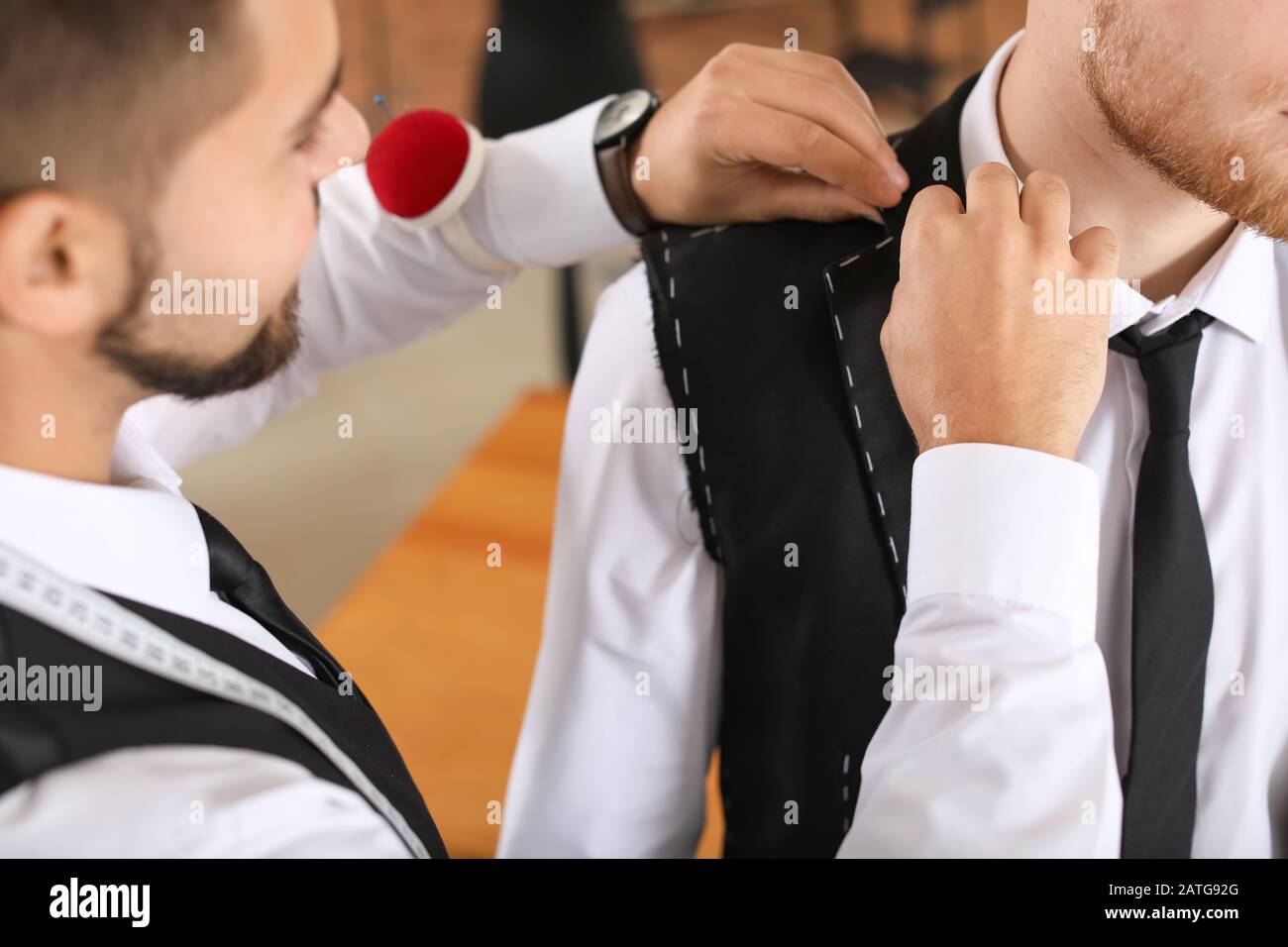 Seamster tailoring suit for male client in atelier Stock Photo - Alamy