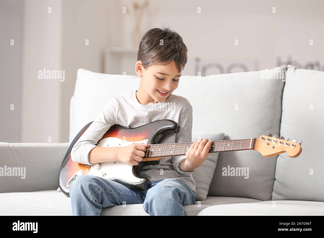 Little boy playing guitar at home Stock Photo - Alamy