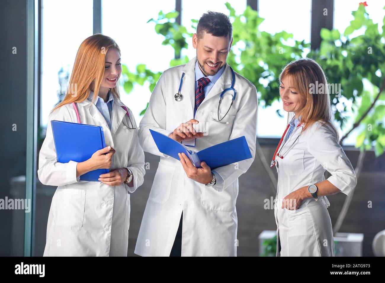 Doctors discussing something in hall of clinic Stock Photo - Alamy