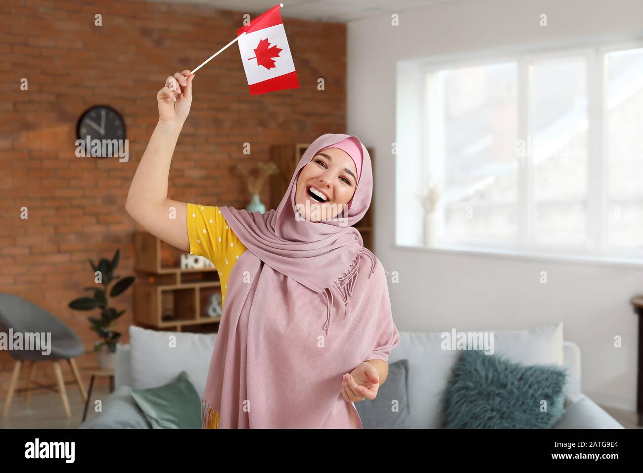 Young Muslim woman with Canadian flag at home Stock Photo - Alamy