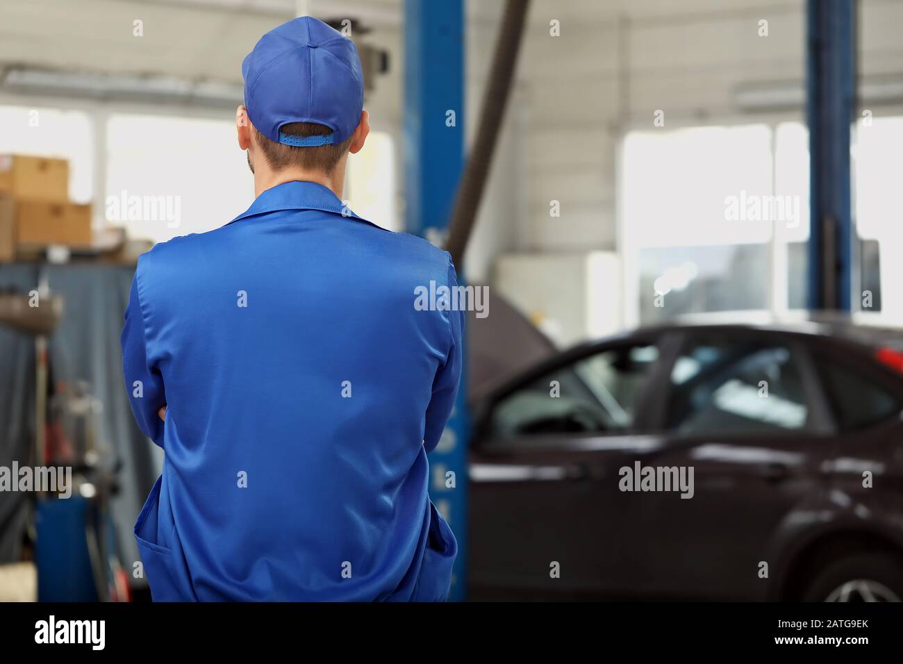 Male mechanic in car service center, back view Stock Photo - Alamy