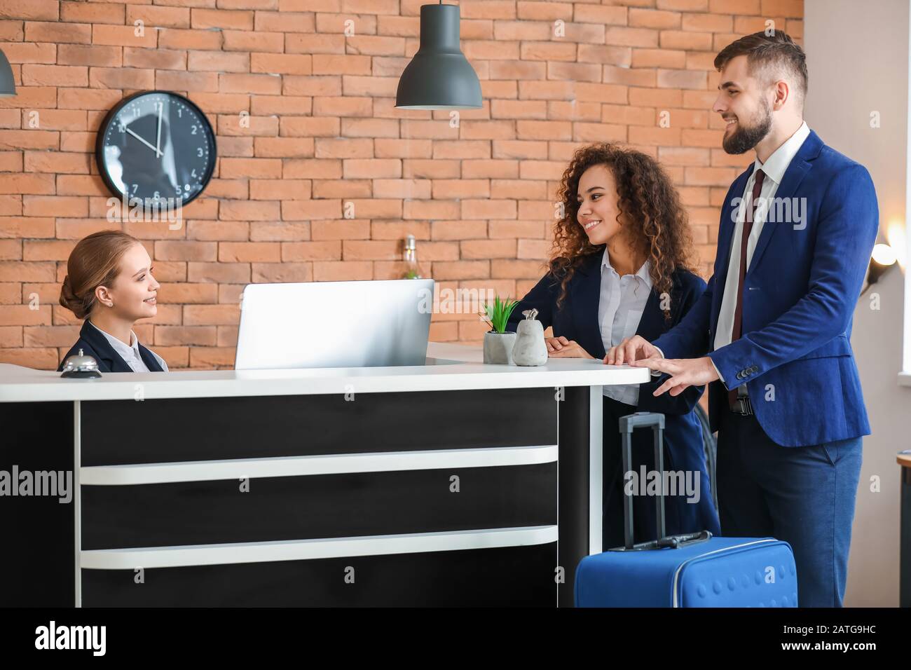 Young female receptionist working with guests in hotel Stock Photo - Alamy