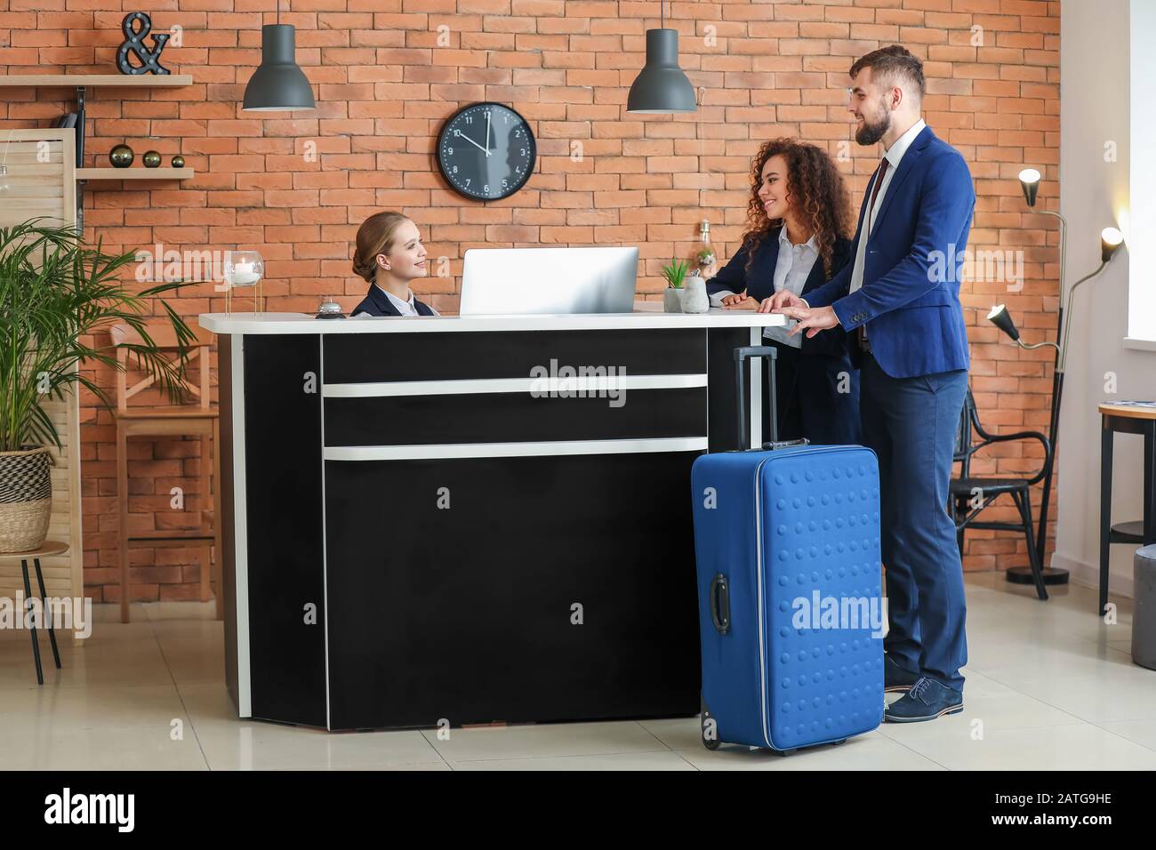 Young female receptionist working with guests in hotel Stock Photo - Alamy