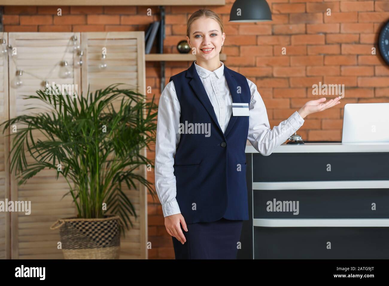 Young female receptionist near desk in hotel Stock Photo - Alamy