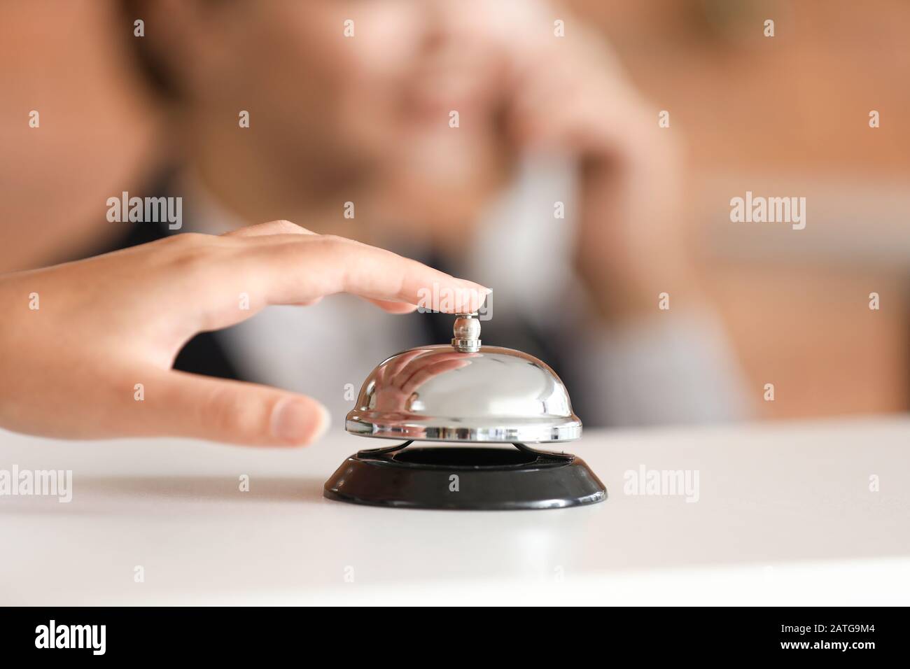 Woman ringing service bell on reception desk in hotel, closeup Stock ...