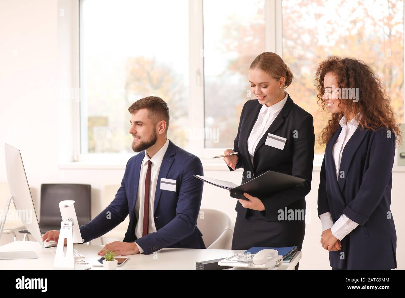 Male and female receptionists working in office Stock Photo - Alamy