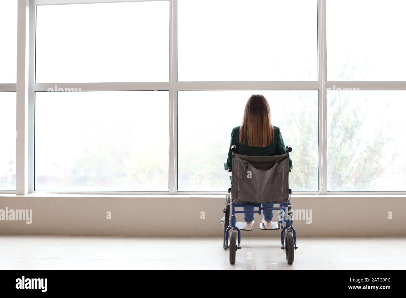 Handicapped young woman in wheelchair near window Stock Photo - Alamy