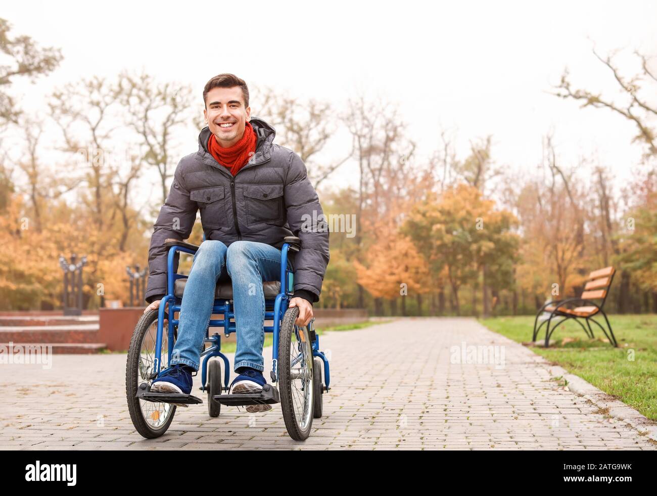 Handicapped young man in autumn park Stock Photo - Alamy