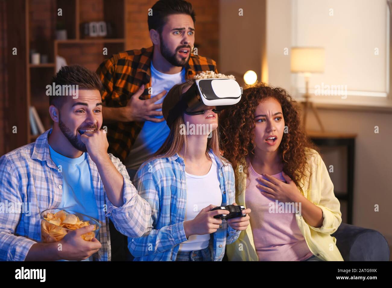 Friends playing video game at home Stock Photo - Alamy