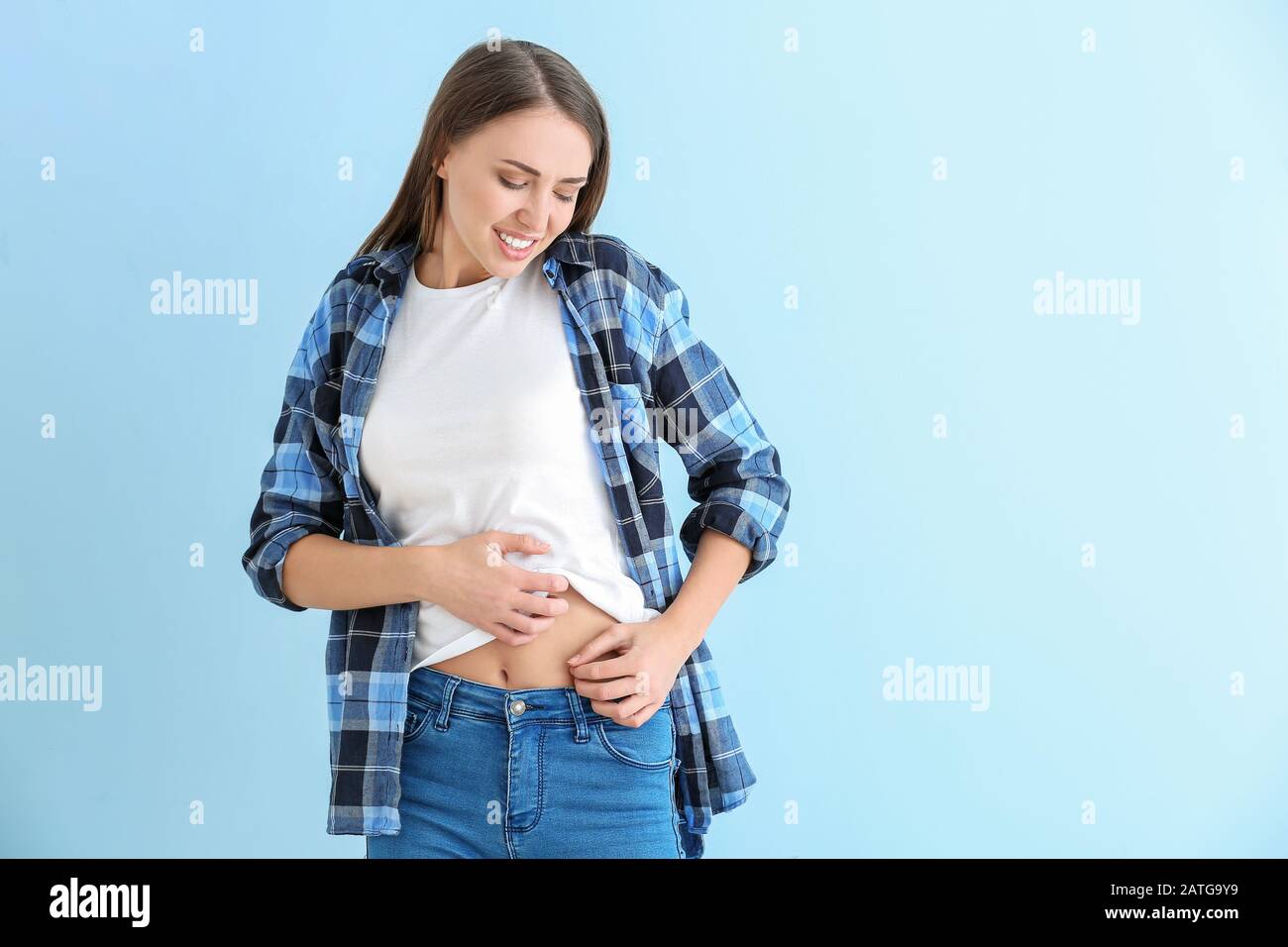Scratching allergic woman on color background Stock Photo - Alamy