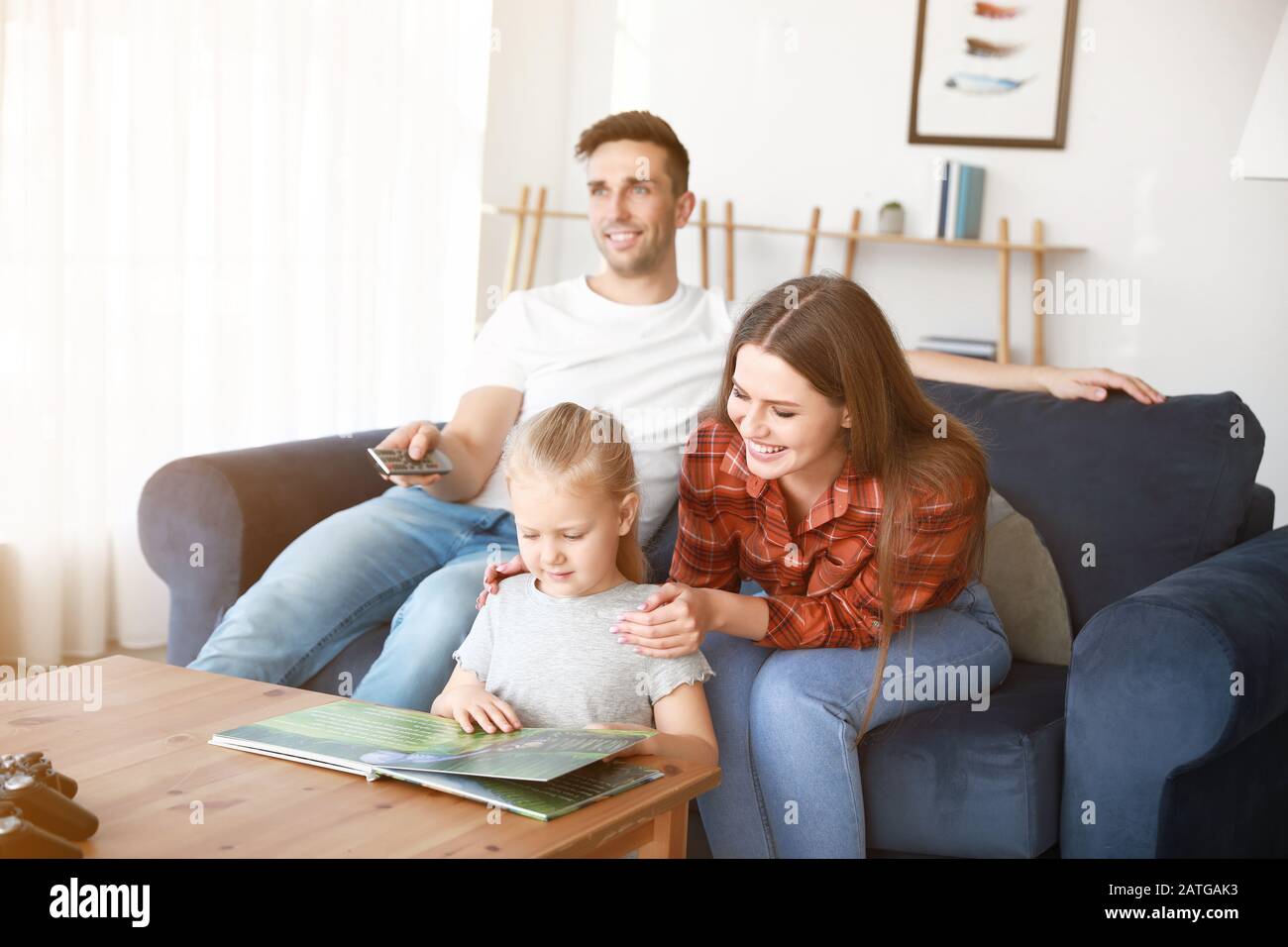 Little girl with parents resting at home Stock Photo - Alamy