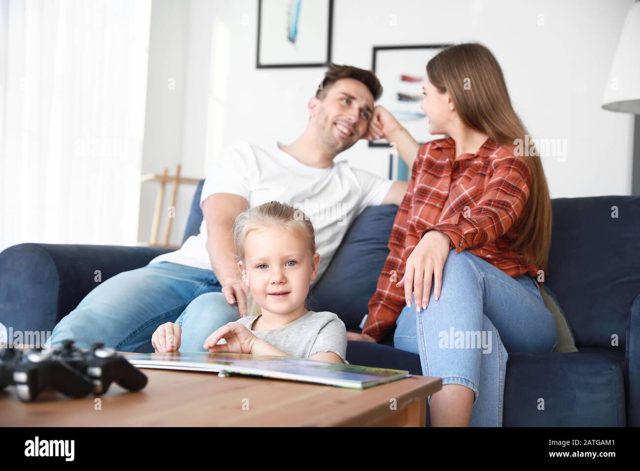 Cute little girl with parents resting at home Stock Photo - Alamy