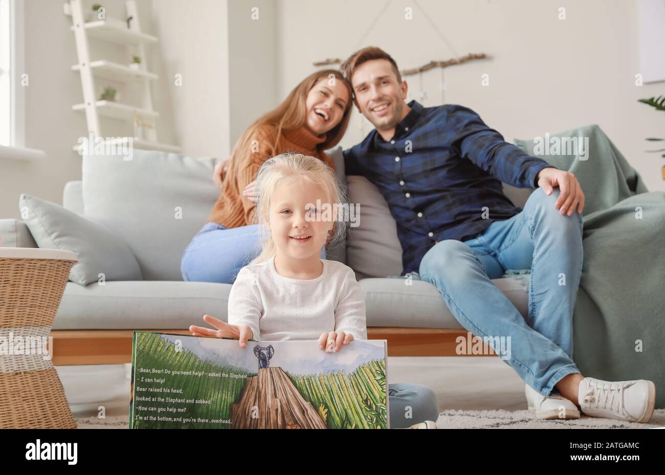 Cute little girl with parents resting at home Stock Photo - Alamy