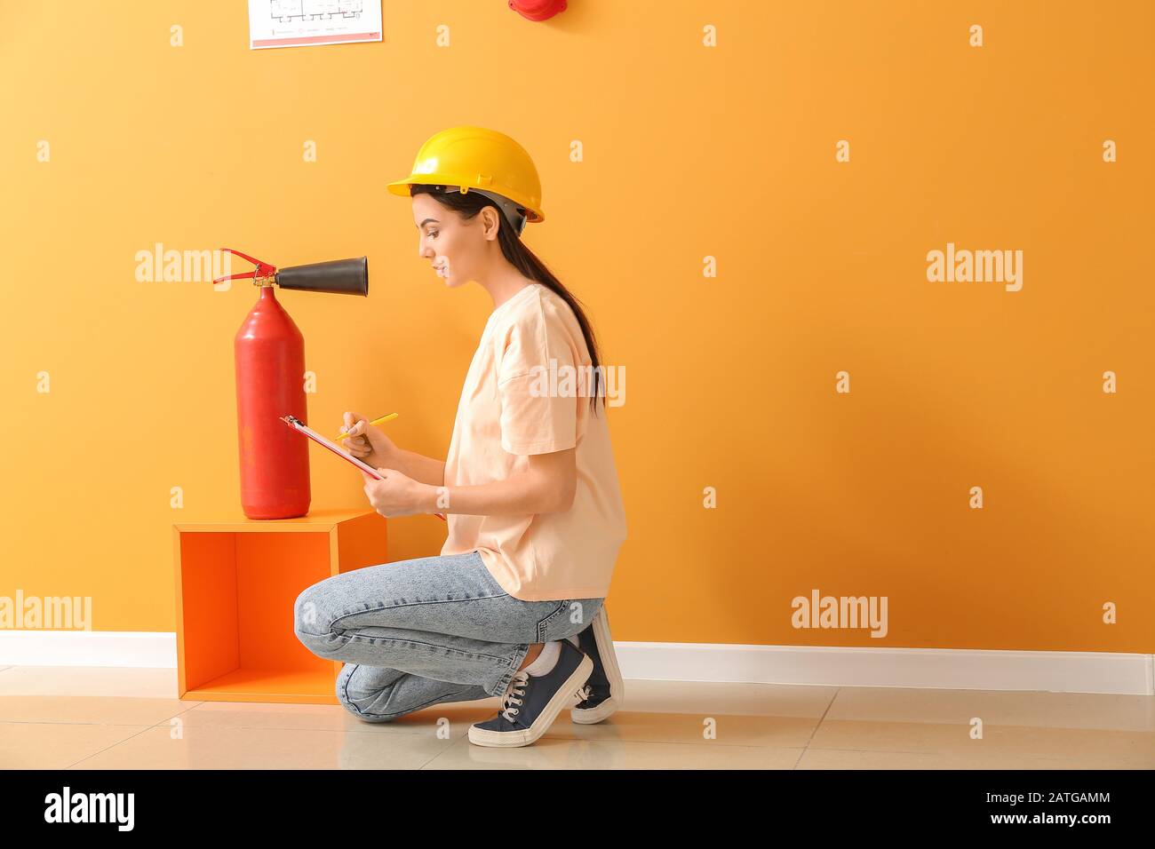 Fire safety specialist inspecting extinguisher Stock Photo - Alamy