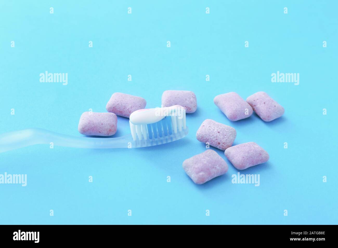 Tooth brush with paste and chewing gums on color background Stock Photo ...