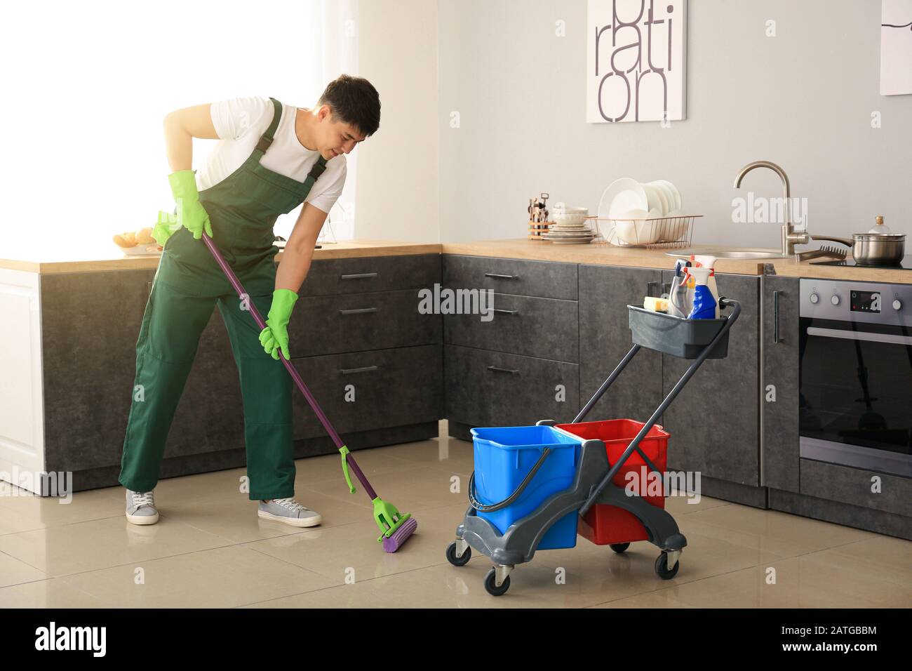 Asian janitor cleaning floor in kitchen Stock Photo - Alamy