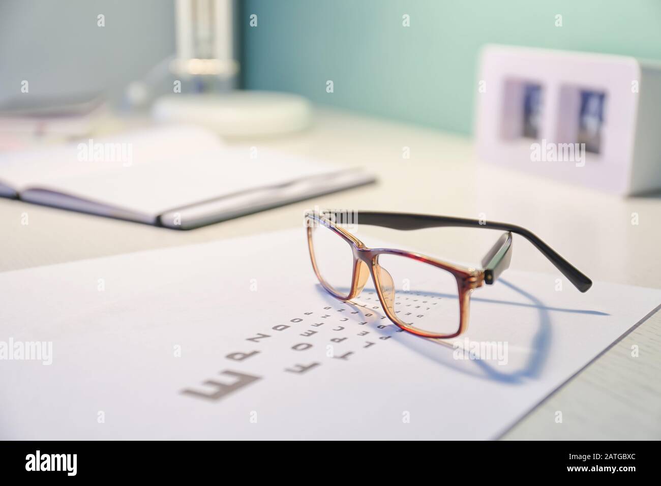 Glasses with eye test chart on table in ophthalmology clinic Stock ...