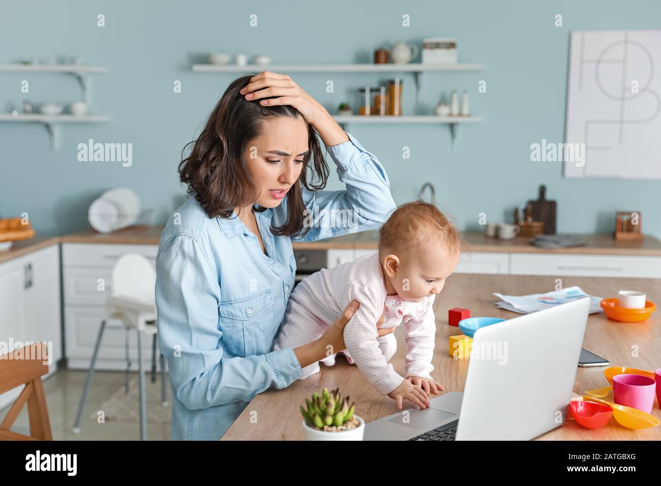Stressed woman at computer with child hi-res stock photography and ...
