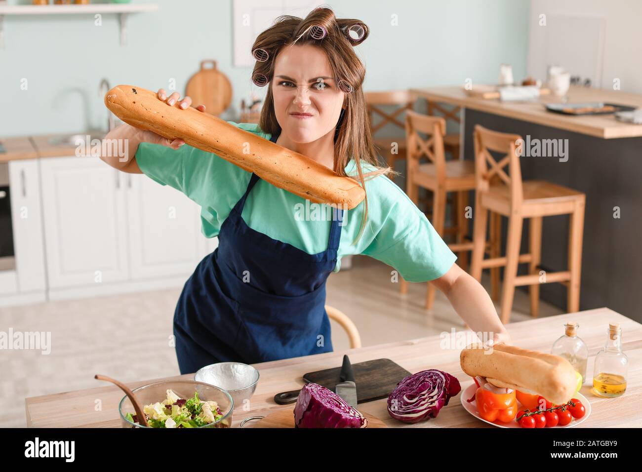 Aggressive young housewife in kitchen Stock Photo - Alamy
