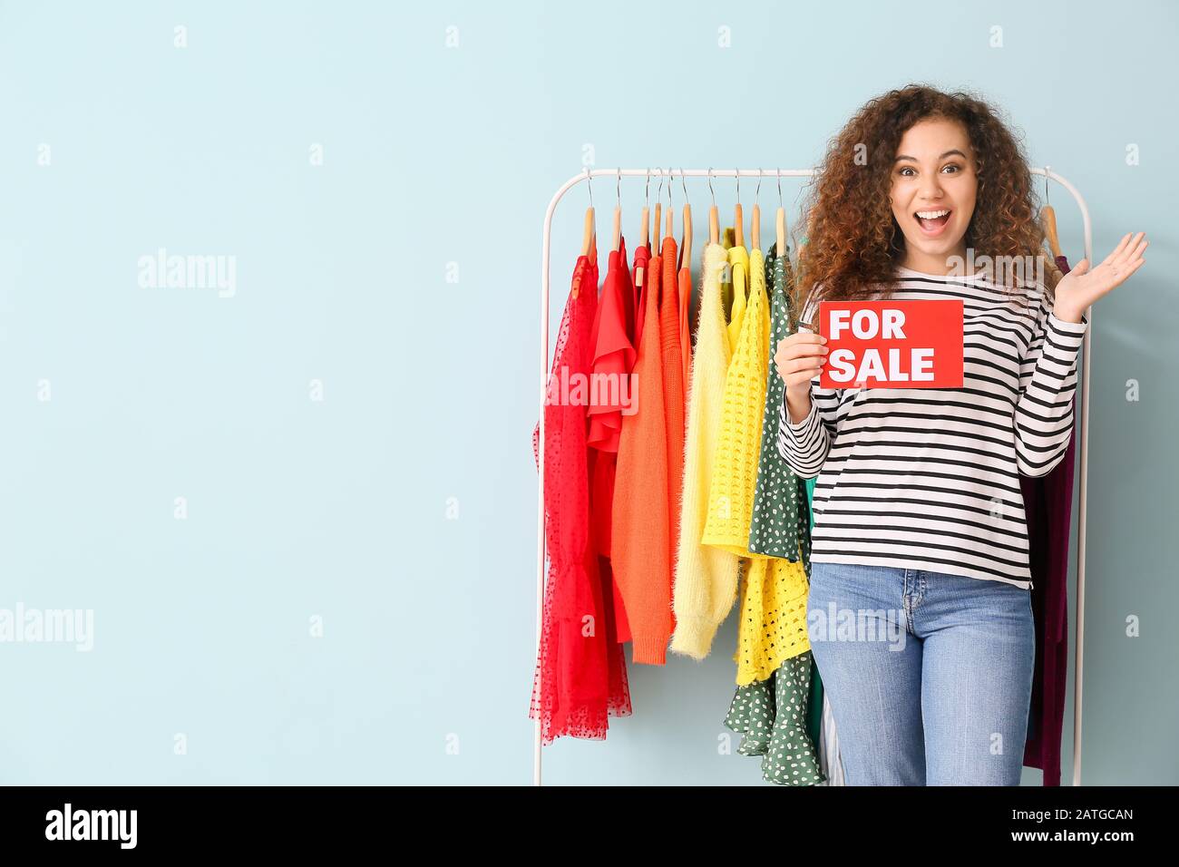 African-American stylist near rack with modern clothes Stock Photo - Alamy