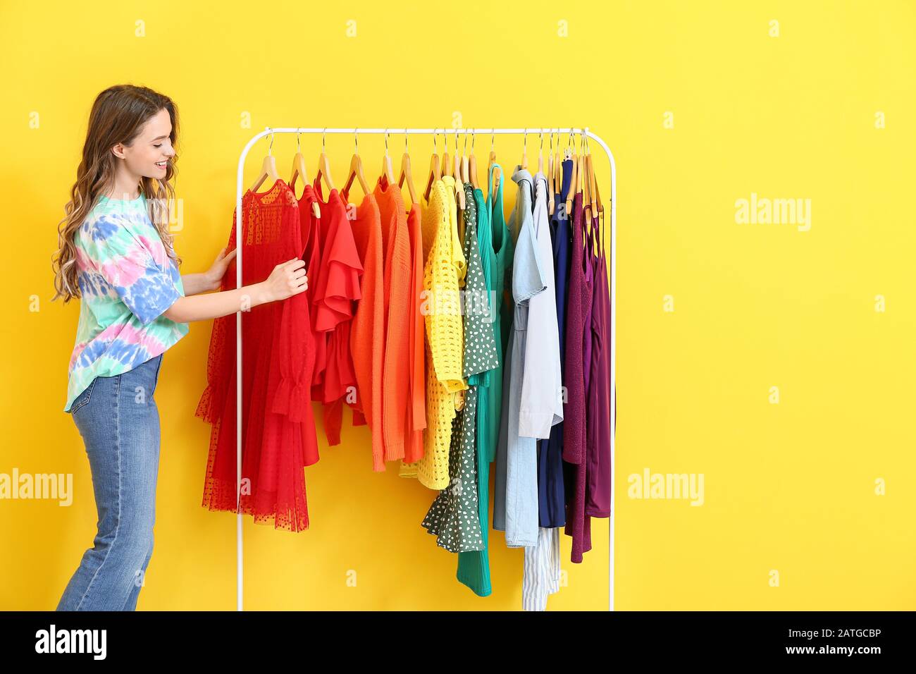 Female stylist near rack with modern clothes Stock Photo - Alamy