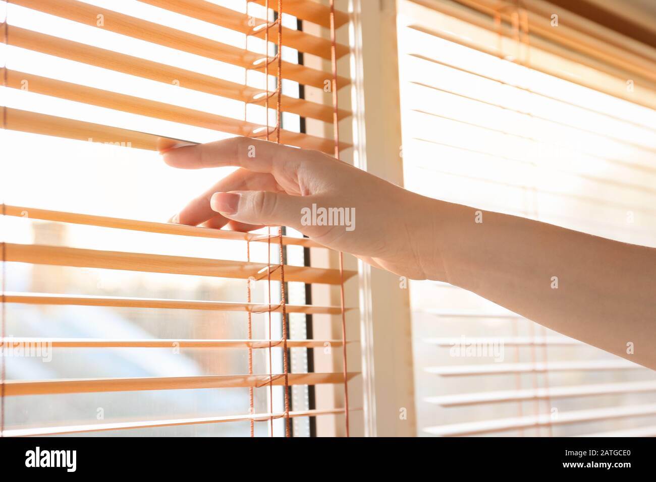 Woman opening blinds apartment hi-res stock photography and images - Alamy