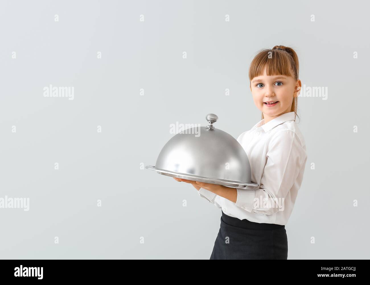 Cute little waiter on light background Stock Photo - Alamy