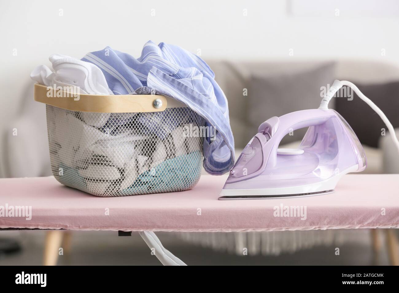 Modern iron and laundry on board in room Stock Photo - Alamy