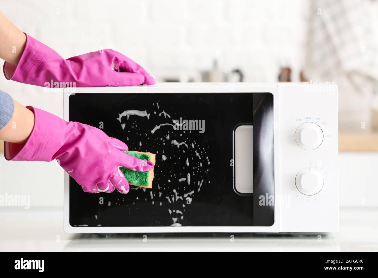 Woman cleaning microwave oven in kitchen Stock Photo - Alamy