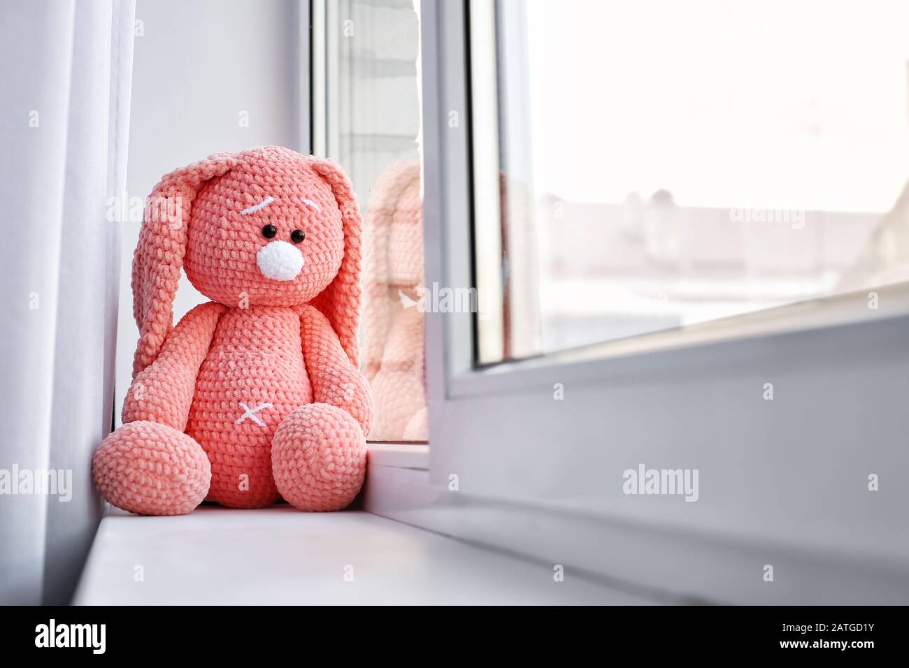 Cute baby toy on window sill Stock Photo - Alamy