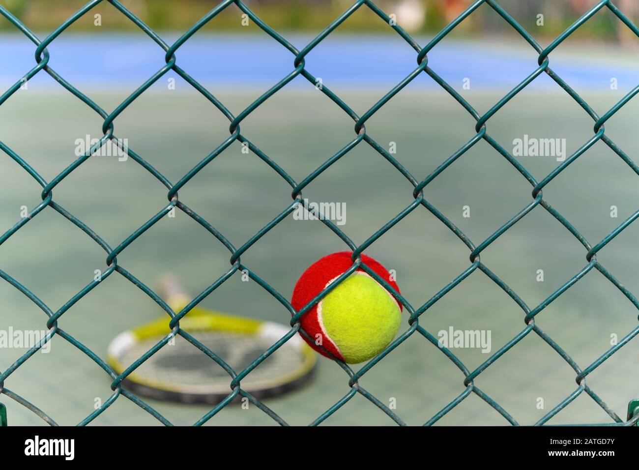 tennis ball stuck on the wire fence of a outdoor court horizontal ...