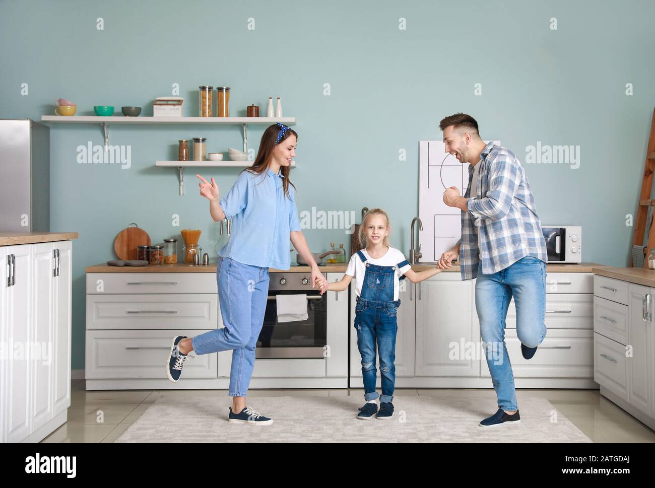 Happy family dancing in kitchen Stock Photo - Alamy