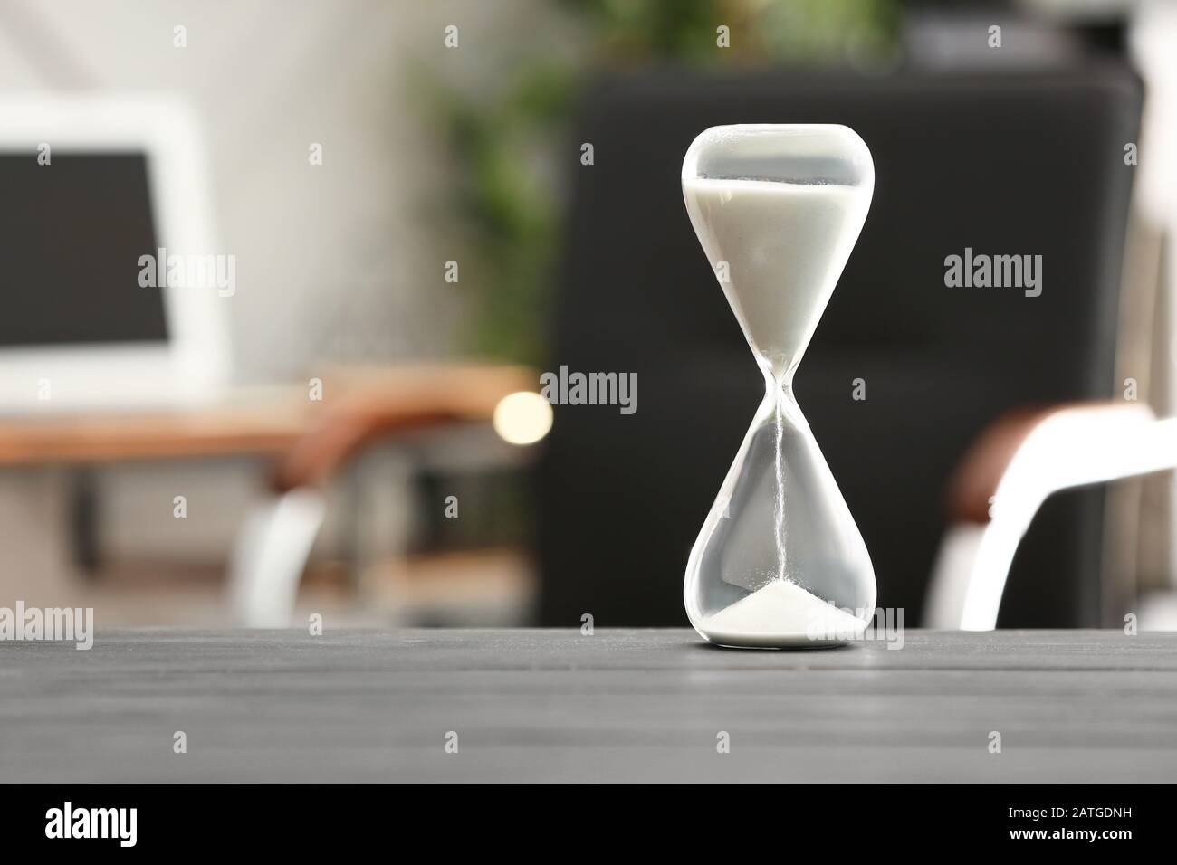 Hourglass on table in office. Time management concept Stock Photo - Alamy