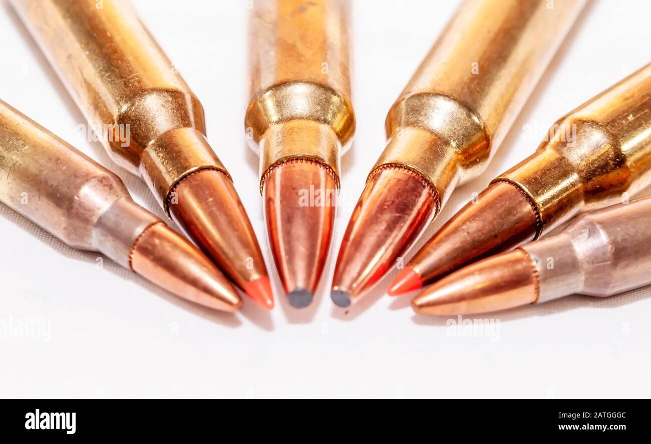 Six rifle bullets, two each of different calibers on a white background ...