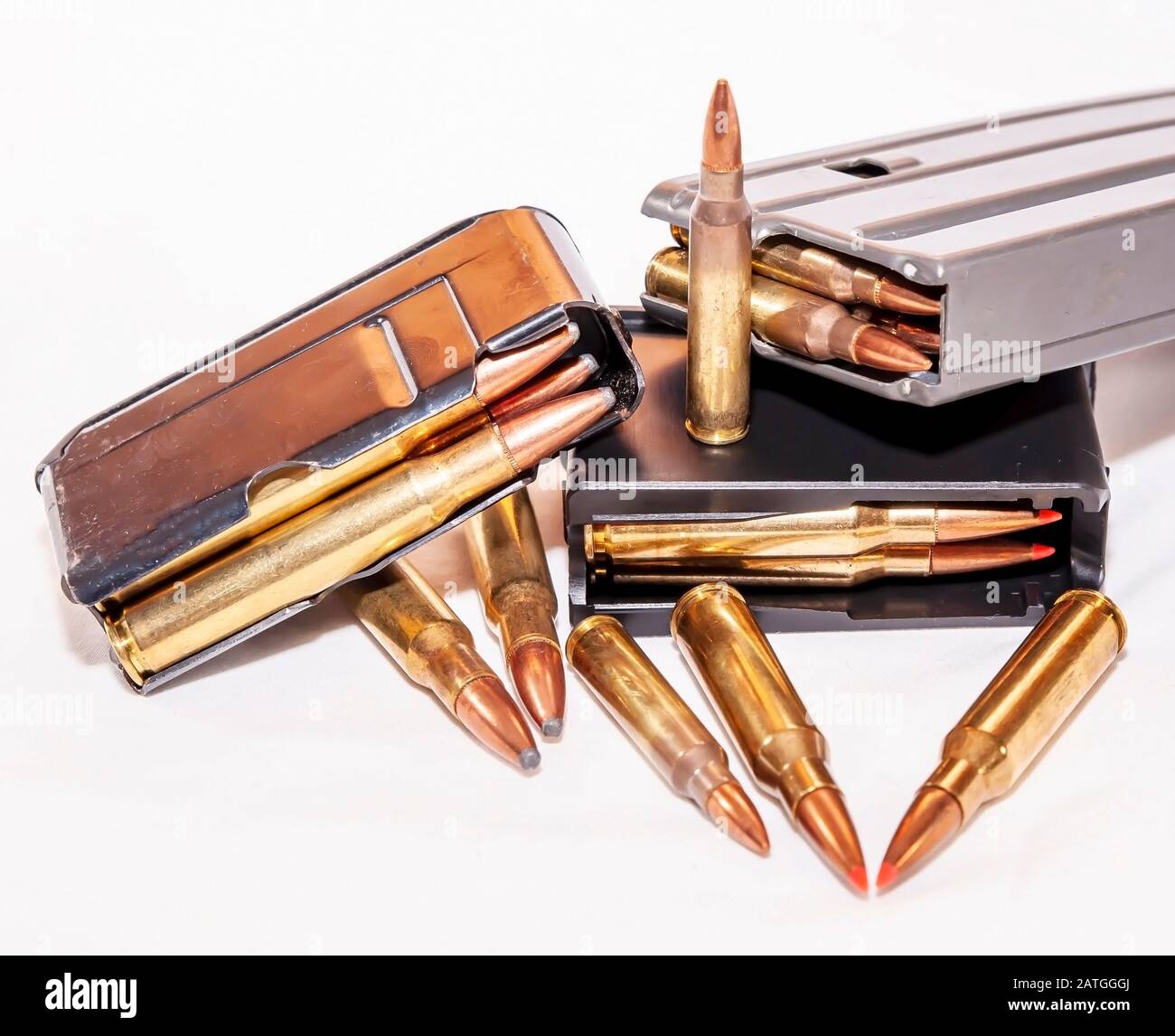 Three different caliber and size loaded rifle magazines with bullets ...