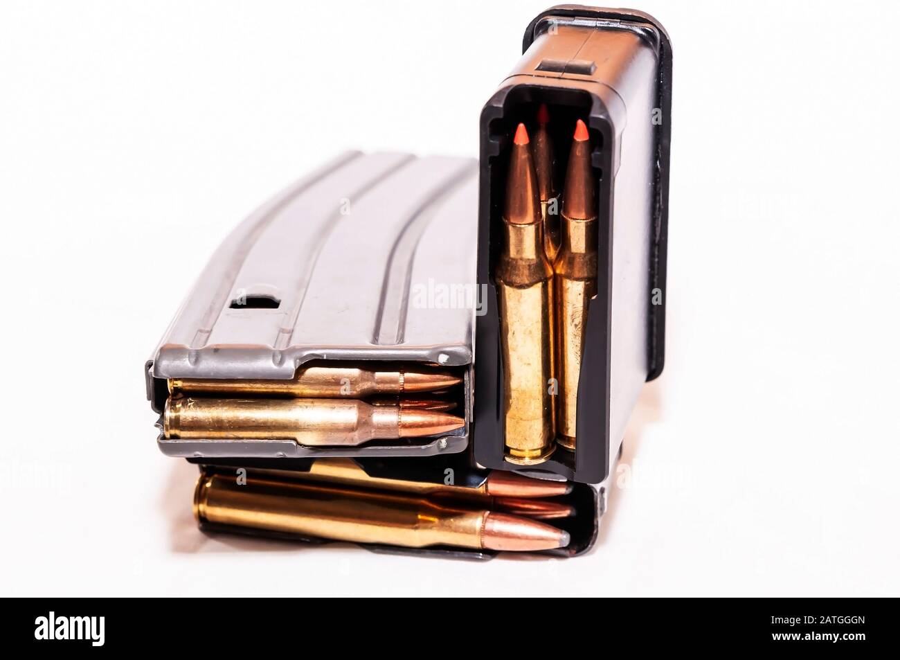 Three different caliber and size loaded rifle magazines on a white ...