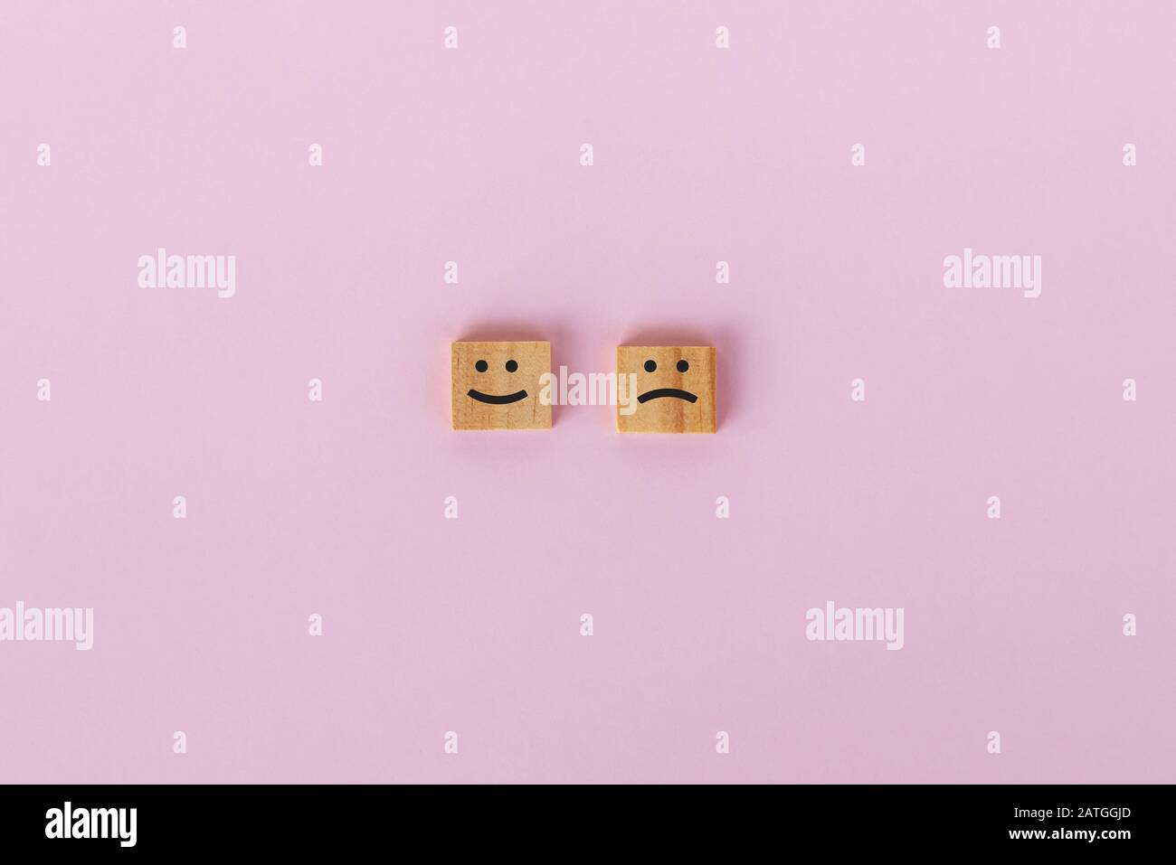 Sad and smiling symbol on wooden block, pink background Stock Photo - Alamy