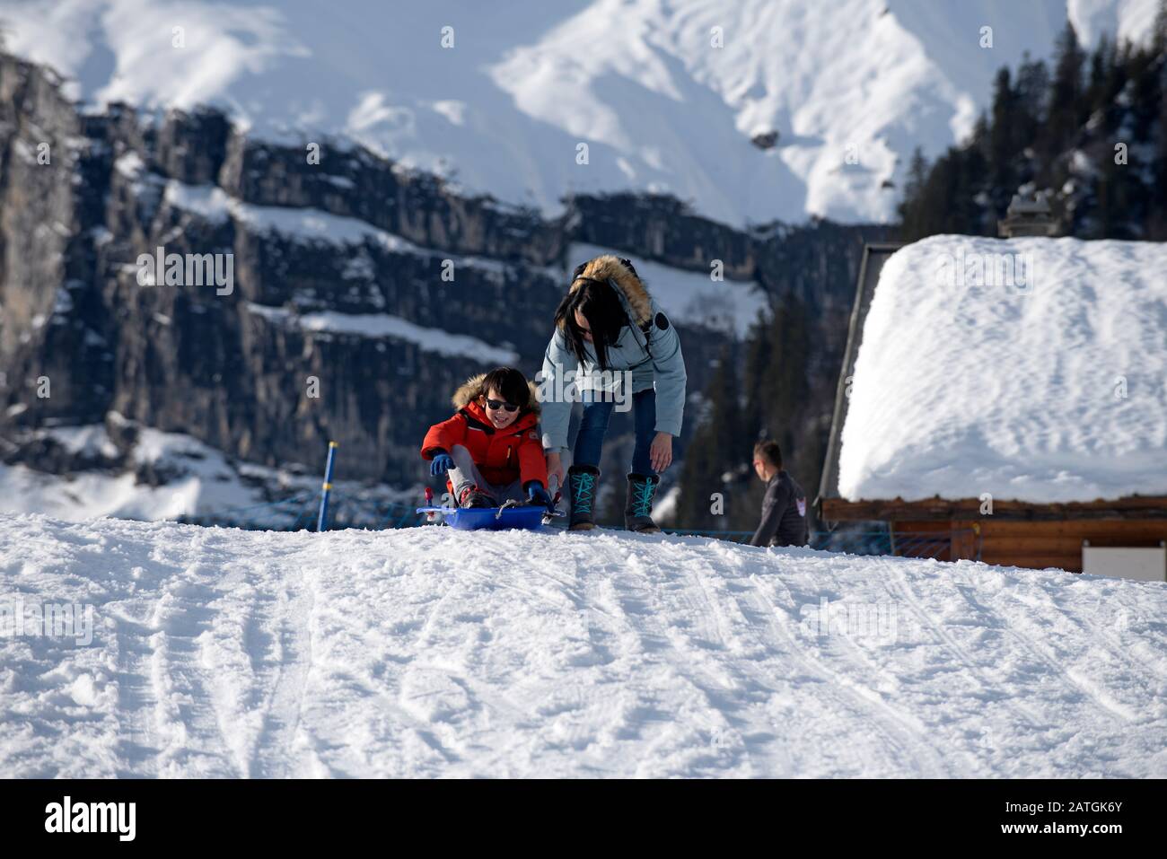 Boy on a sledge in winter with mother Stock Photo - Alamy