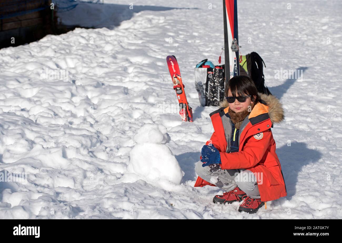 Boy making a snowman Stock Photo - Alamy
