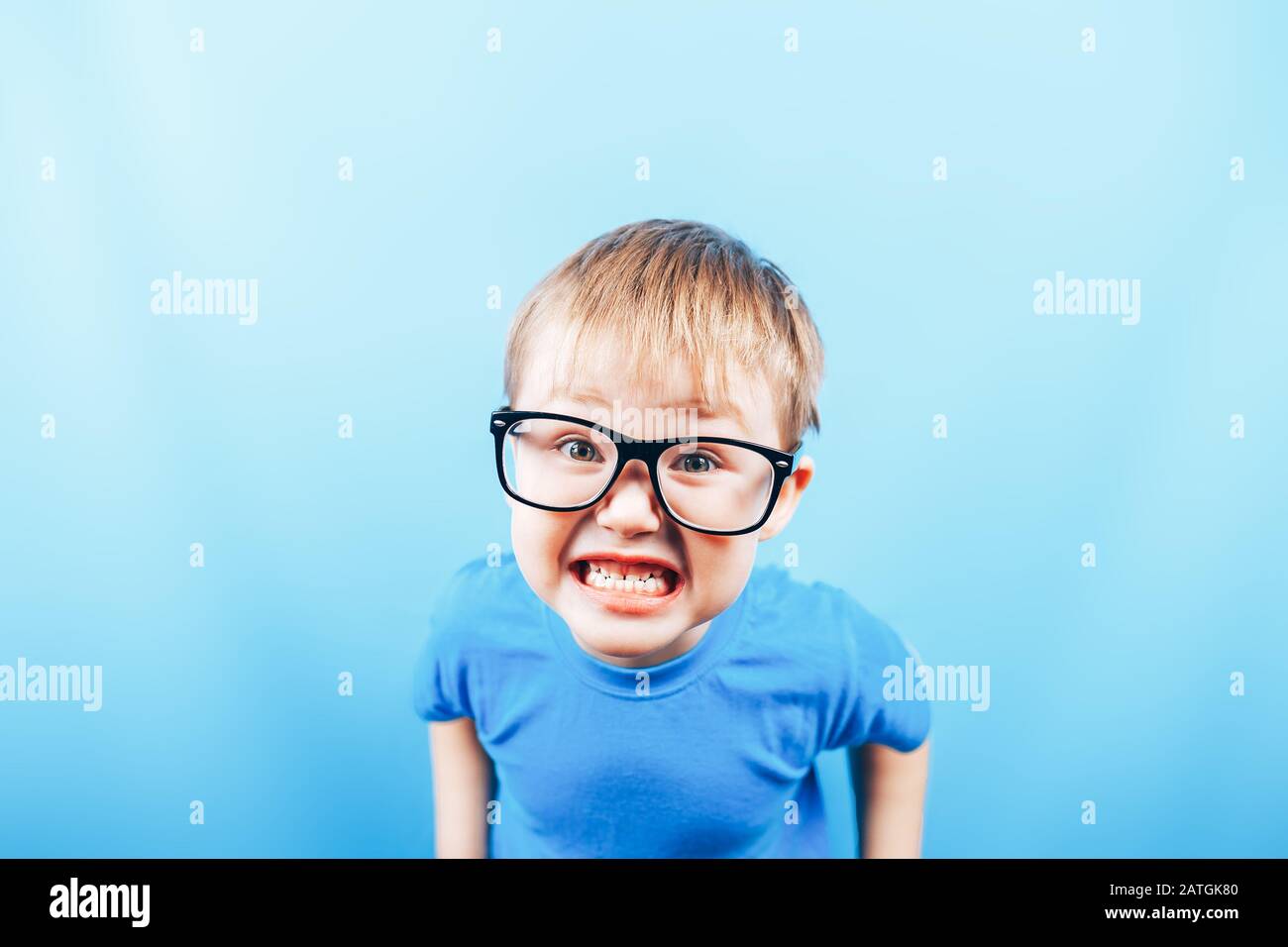 Angry small boy looking at camera in glasses Stock Photo - Alamy