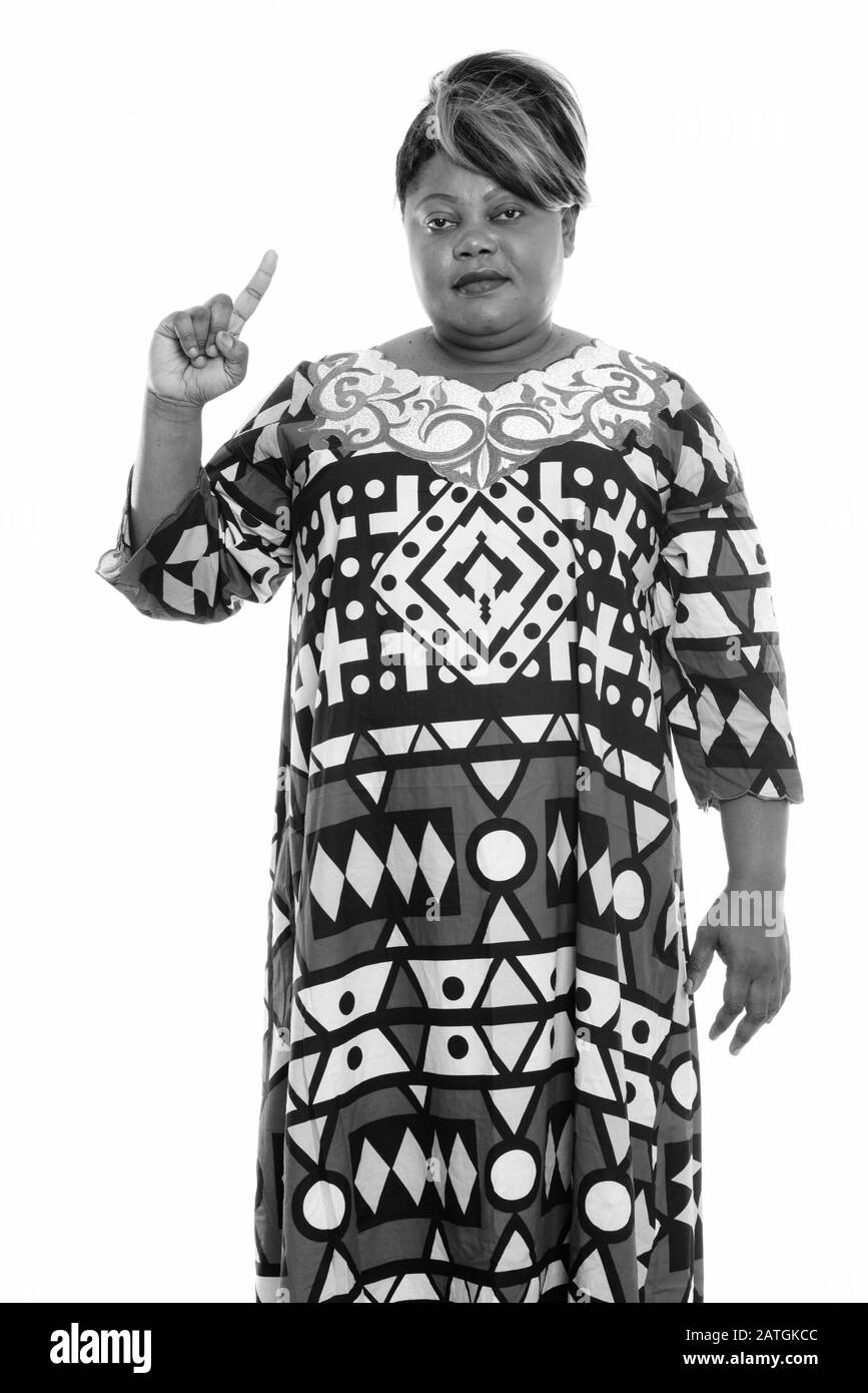Studio shot of overweight African woman standing while pointing finger ...