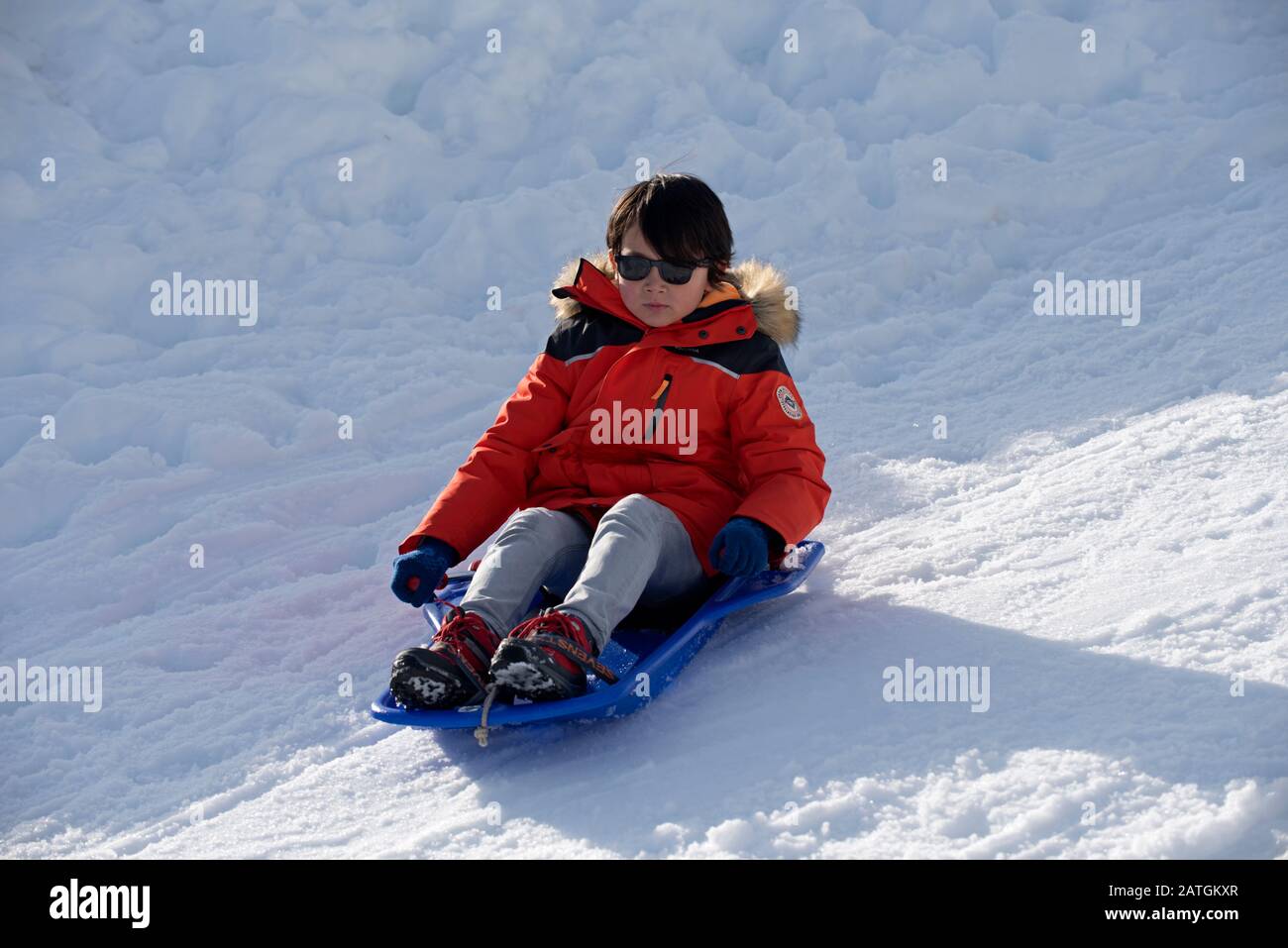 Boy on a sledge in winter Stock Photo - Alamy