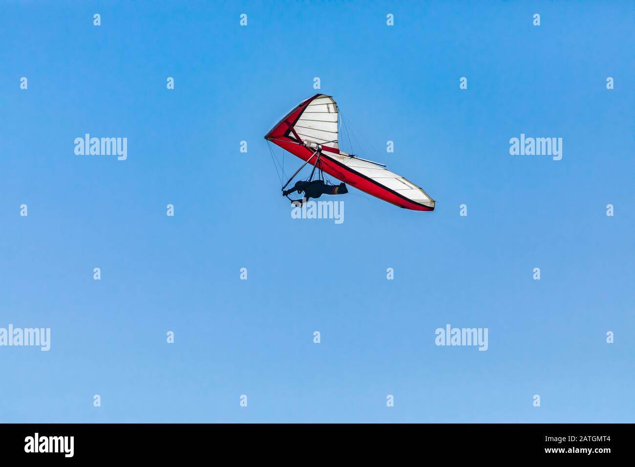 Overhead view of flying hang-gliding against the clear blue sky. Hang ...